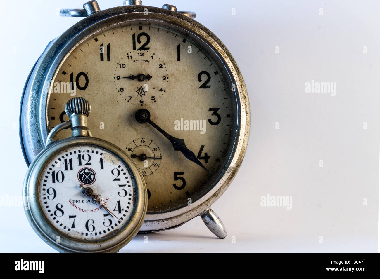 An old rusty alarm-clock with a pocket clock on white background Stock ...