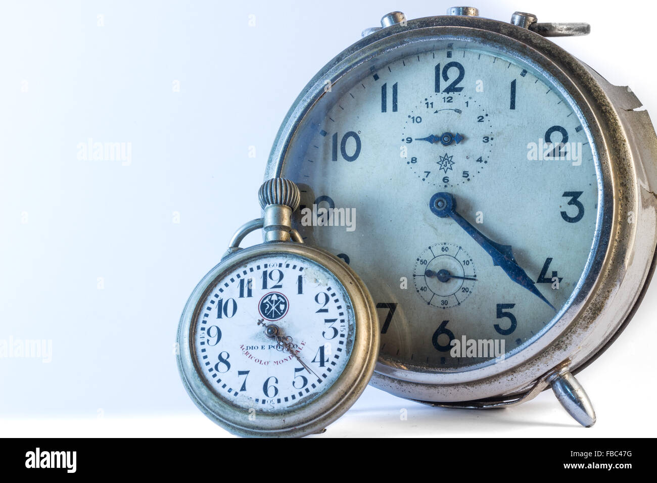 An old rusty alarm-clock with a pocket clock on white background Stock ...