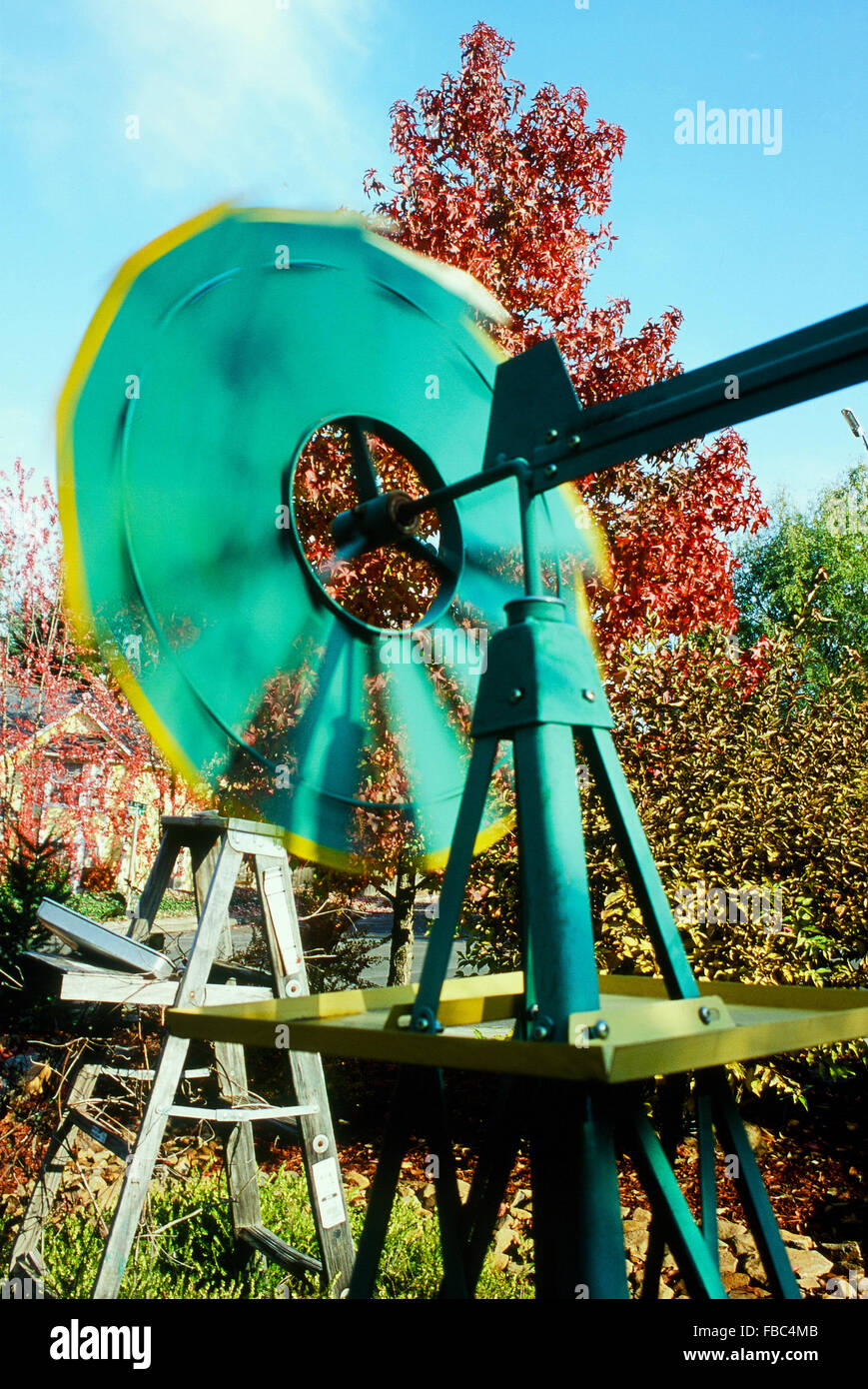 Green antique windmill turning in the wind in a garden Stock Photo - Alamy