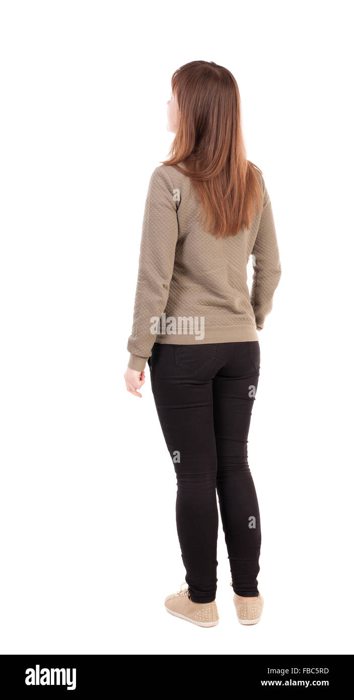 back view of standing young beautiful woman in jeans. girl watching ...