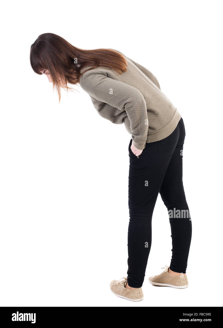 back view of standing young beautiful woman in jeans looks down. girl ...
