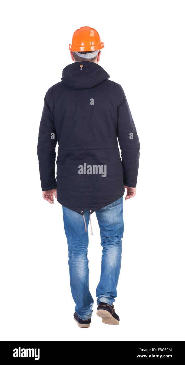 Back view of goingWorker in a helmet. walking young engineer. Rear view ...