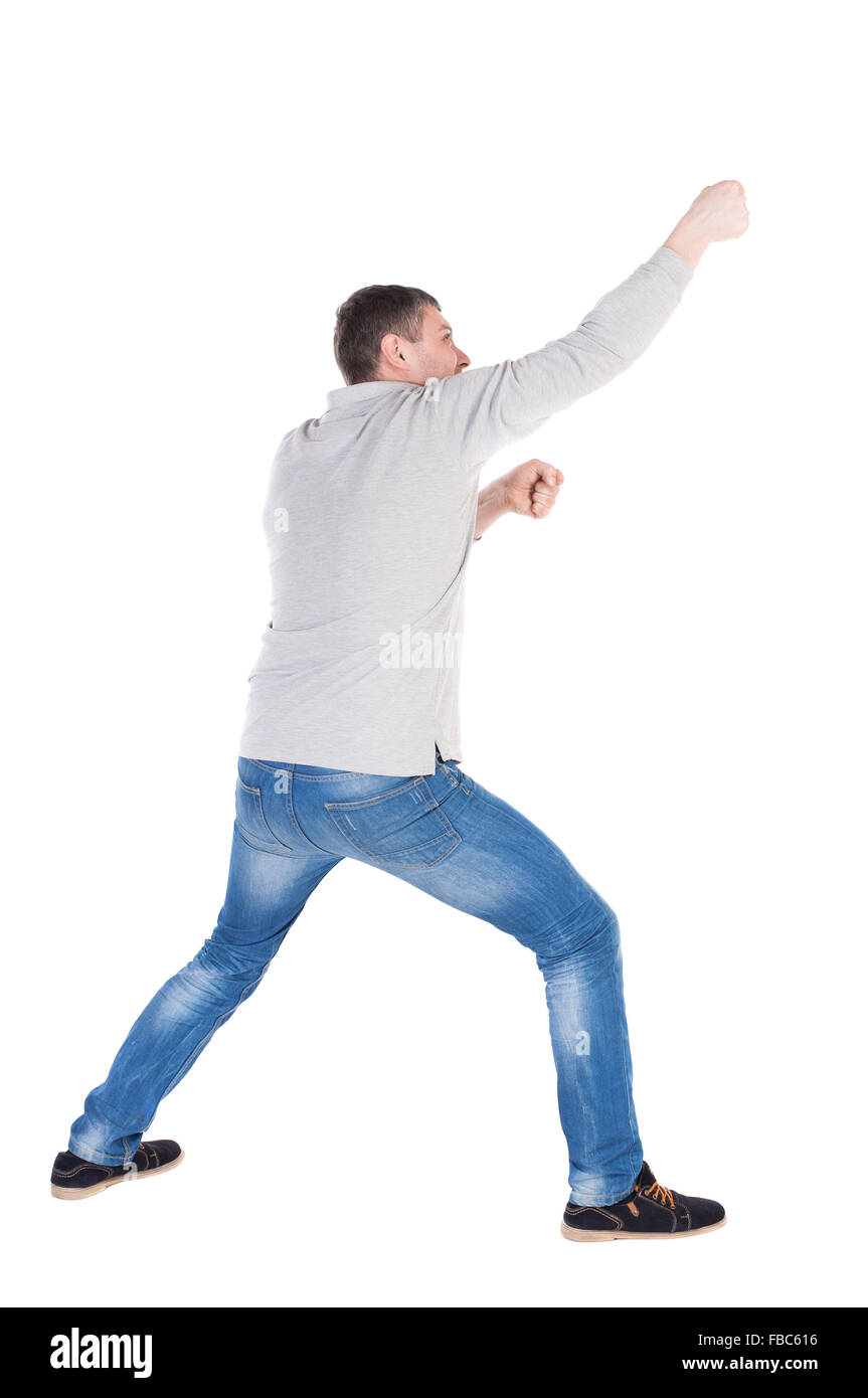 back view of standing man pulling a rope from the top or cling to ...