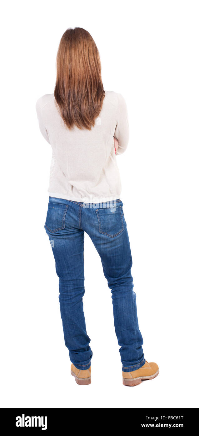 back view of standing young beautiful woman in jeans. girl watching ...