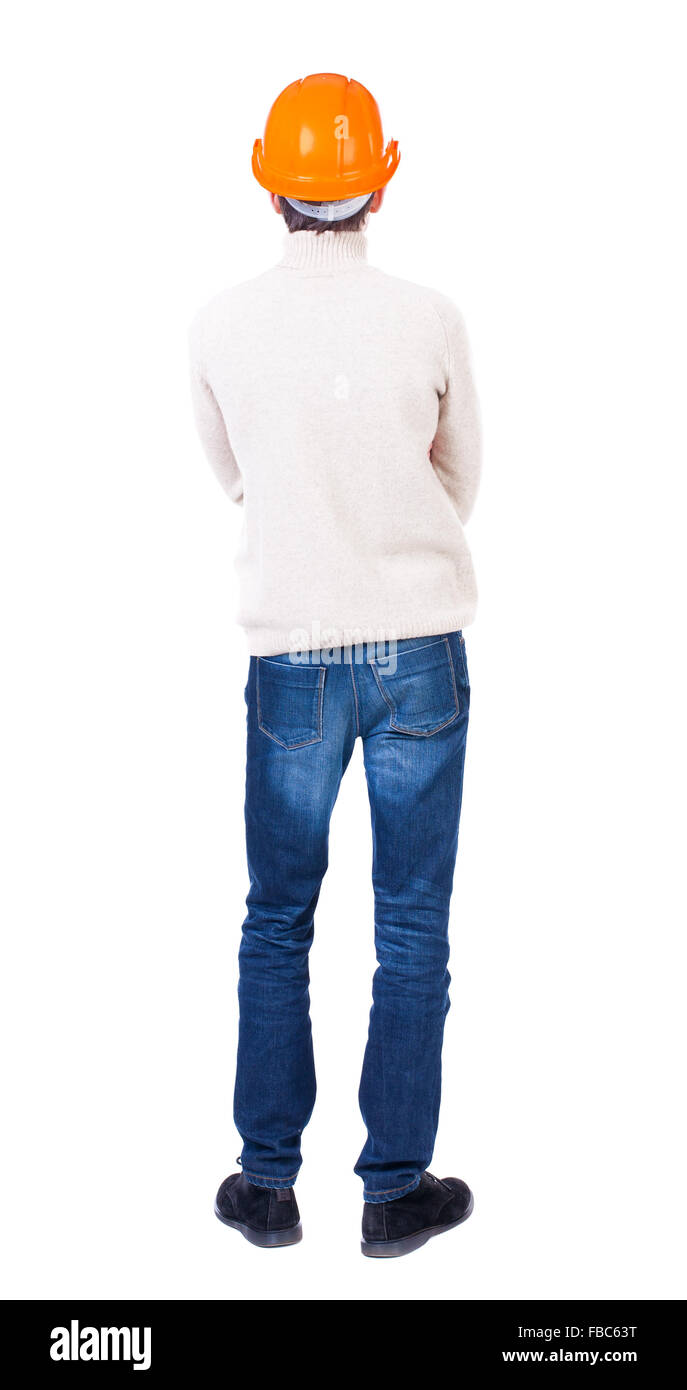 Backview of an engineer in construction helmet stands. Standing young ...