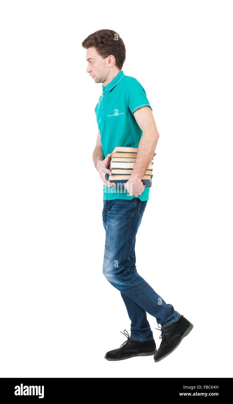 Back view of going handsome man carries a stack of books. walking young ...