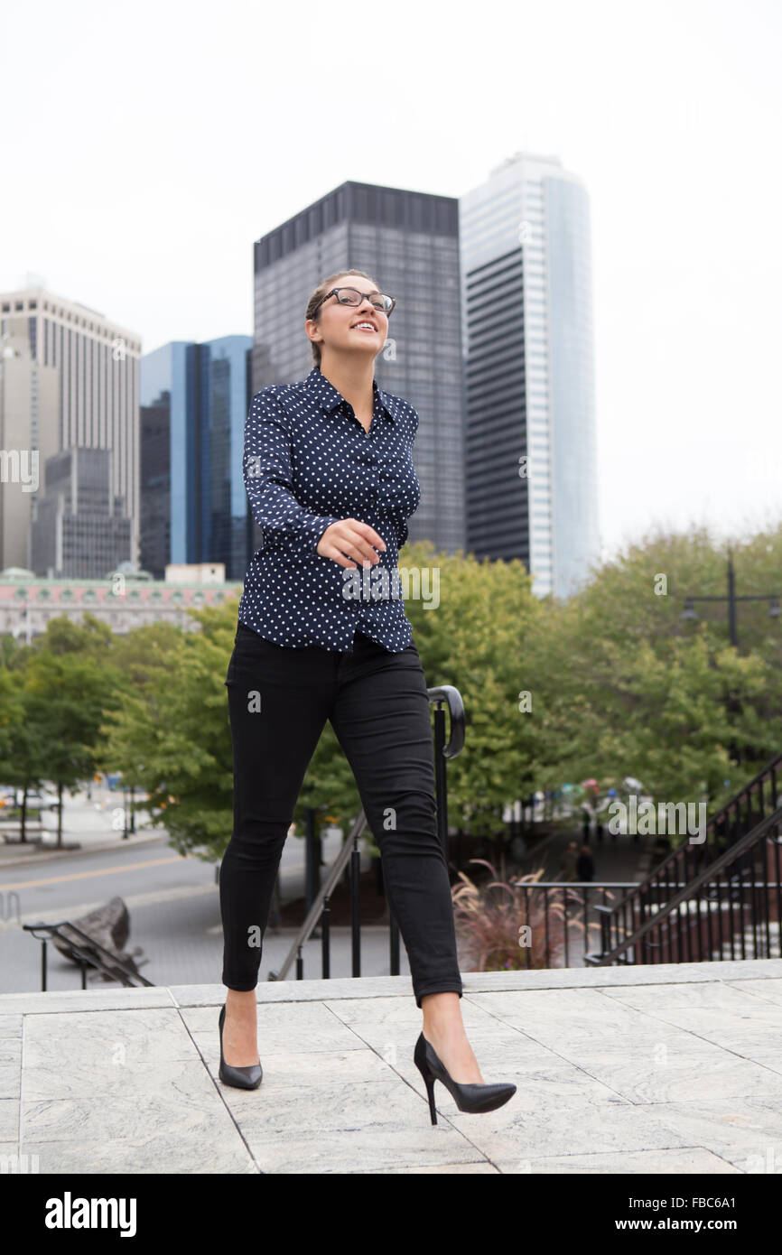 A young professional business woman walking in the city. Photographed ...