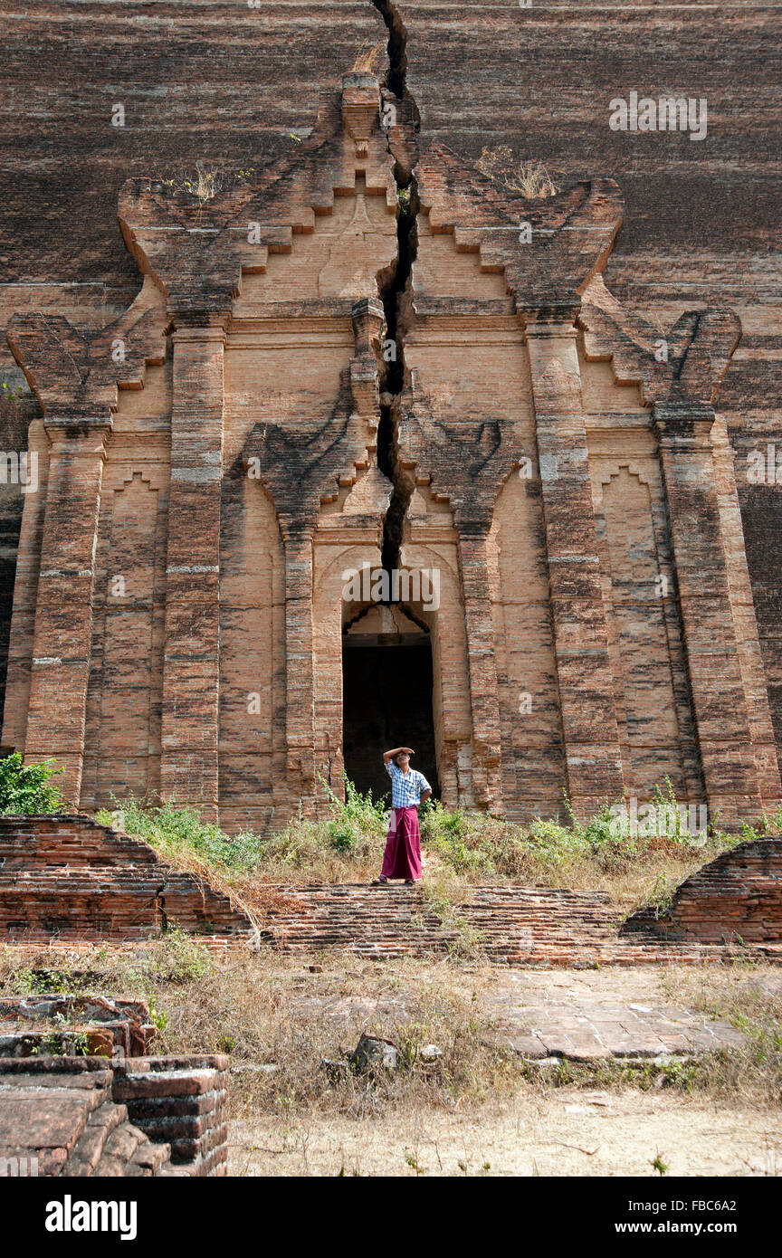 A Burmese man stands in front of the earthquake damaged huge brick ...