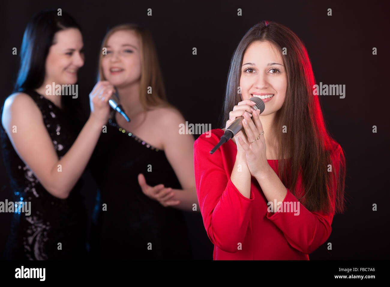 Portrait of beautiful smiling with bliss female singer with microphone ...