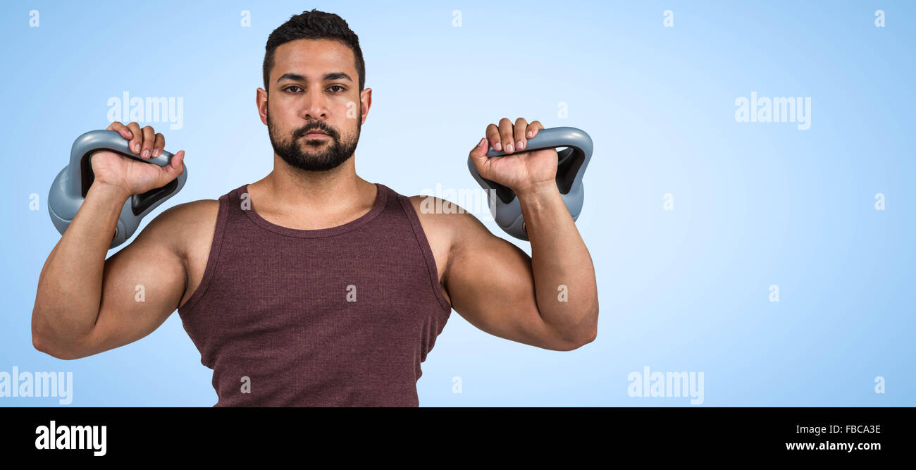 Composite image of muscular serious man lifting kettlebells Stock Photo ...