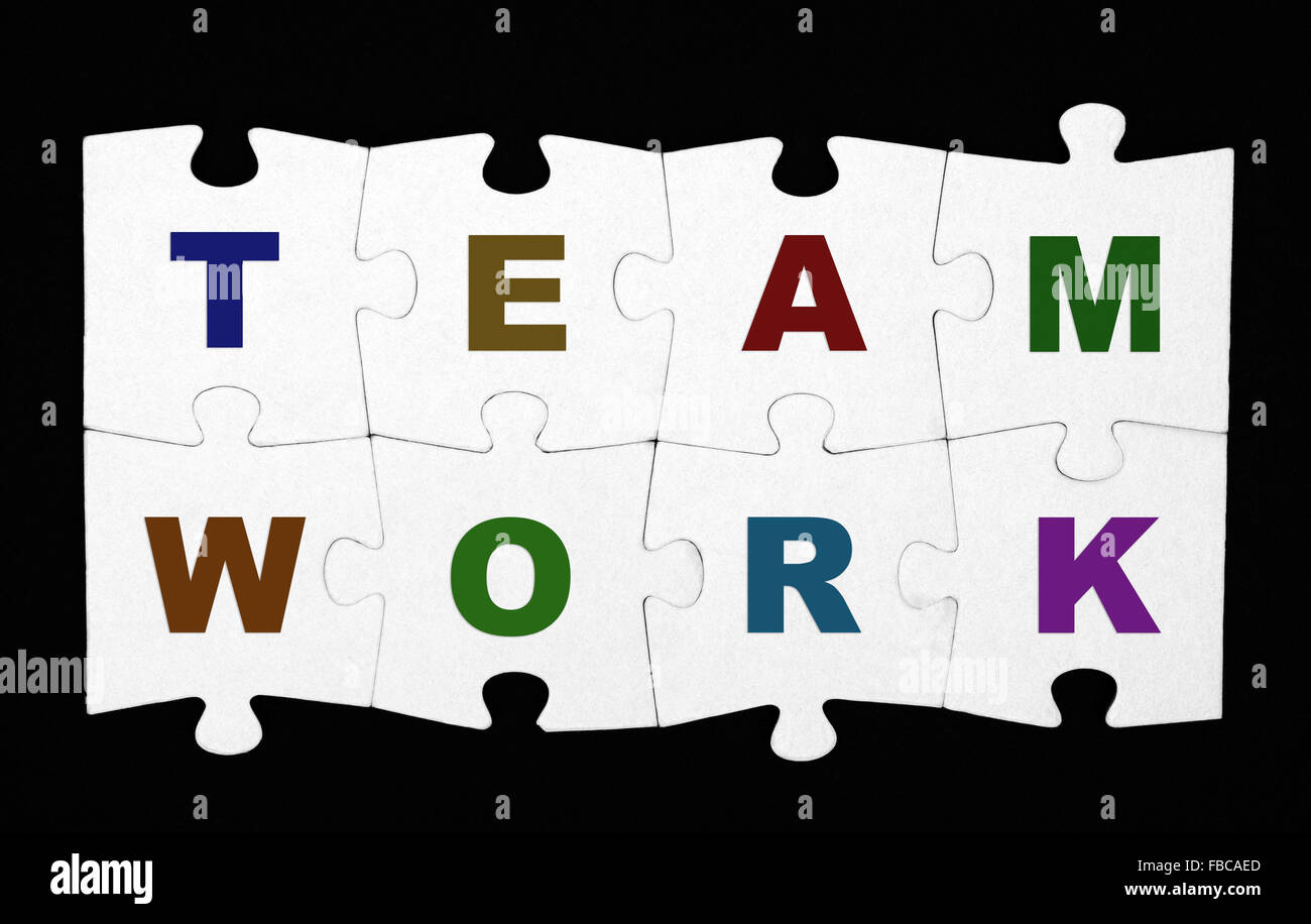 Teamwork puzzle on black background Stock Photo - Alamy