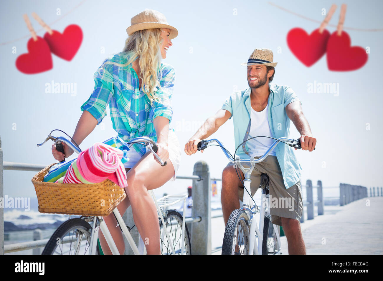 Composite image of couple on bike ride by the beach Stock Photo - Alamy
