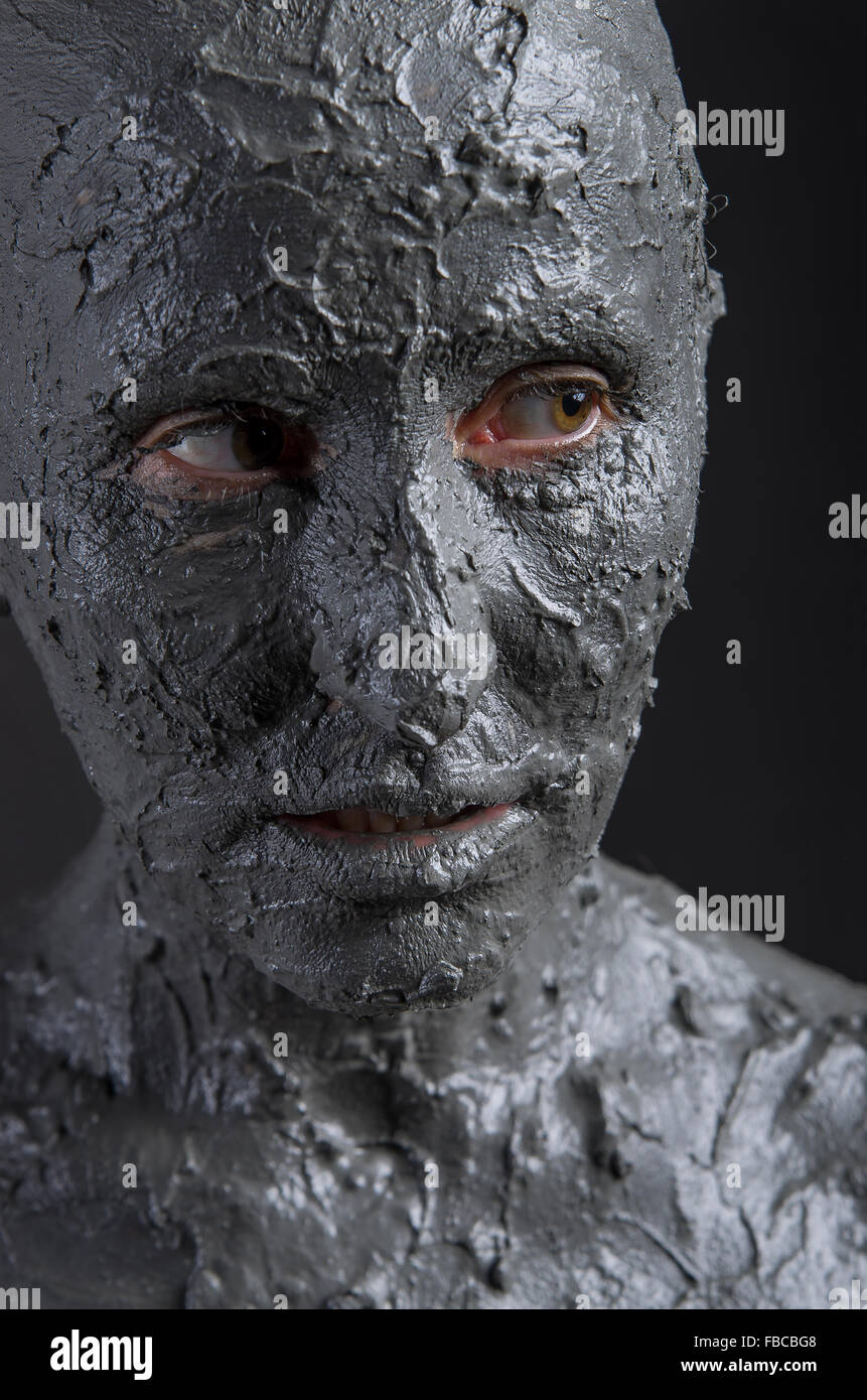 Statuesque woman in clay. Woman covered in clay. Spa treatment or ...