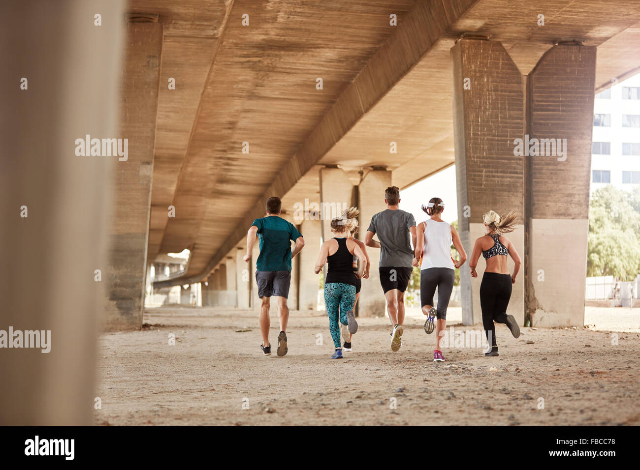 Rear view of healthy young people running together. Running club group ...