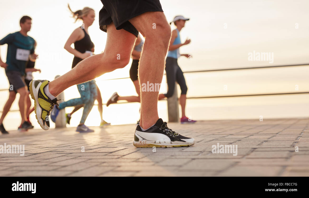 Closeup portrait of people running on road by the sea with focus on ...