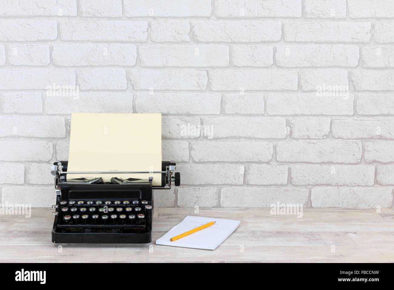 Vintage typewriter, notepad and pencil on old shabby wood effect desk ...