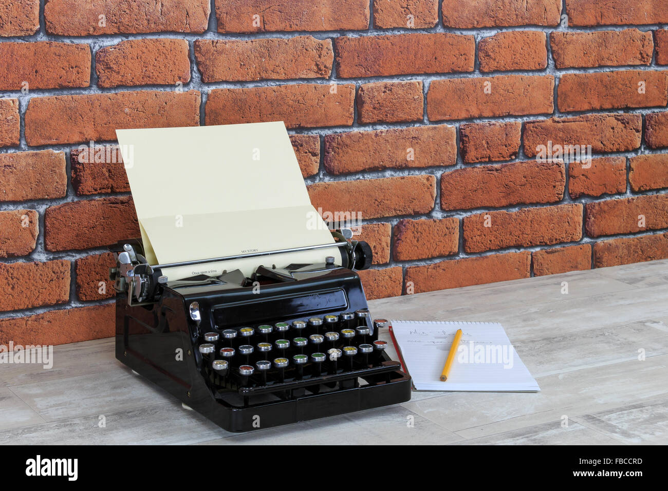 Vintage typewriter, notepad and pencil on old shabby wood effect desk ...
