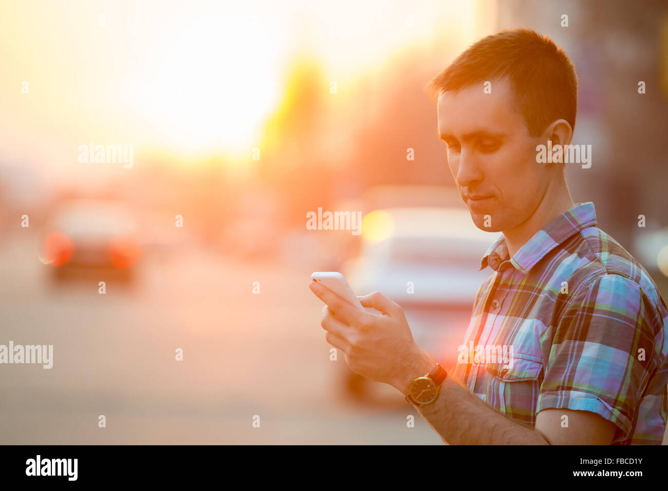 Young man holding mobile phone, using smartphone app, scrolling ...