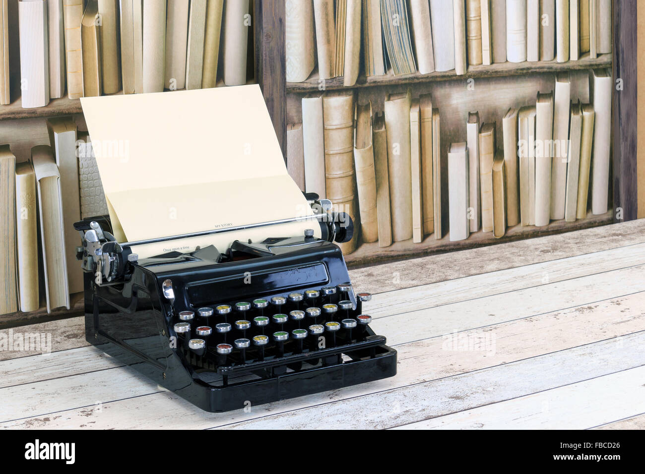Vintage typewriter on old shabby wood effect desktop with old bookcase ...