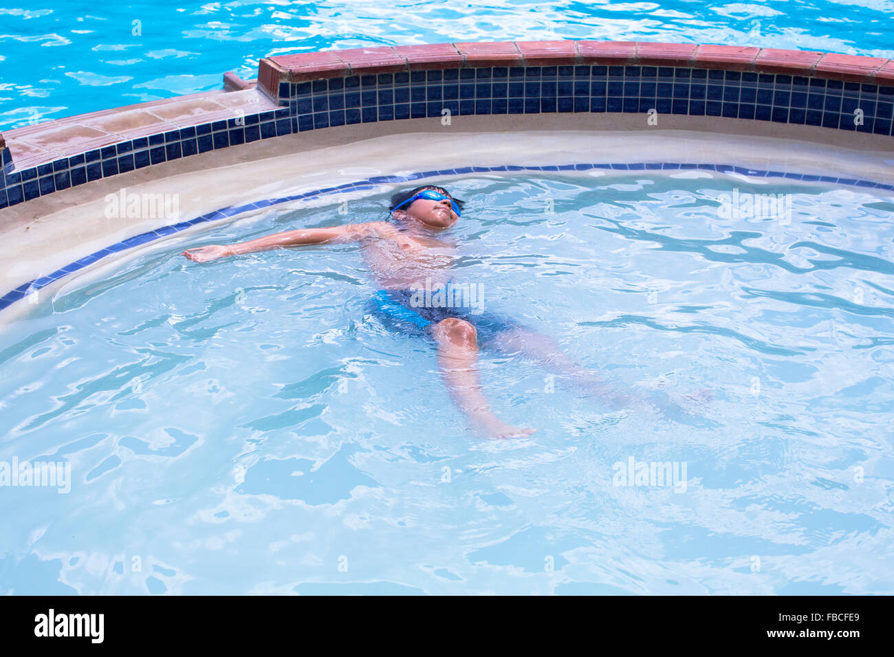 Boy floating in a swimming pool Stock Photo - Alamy