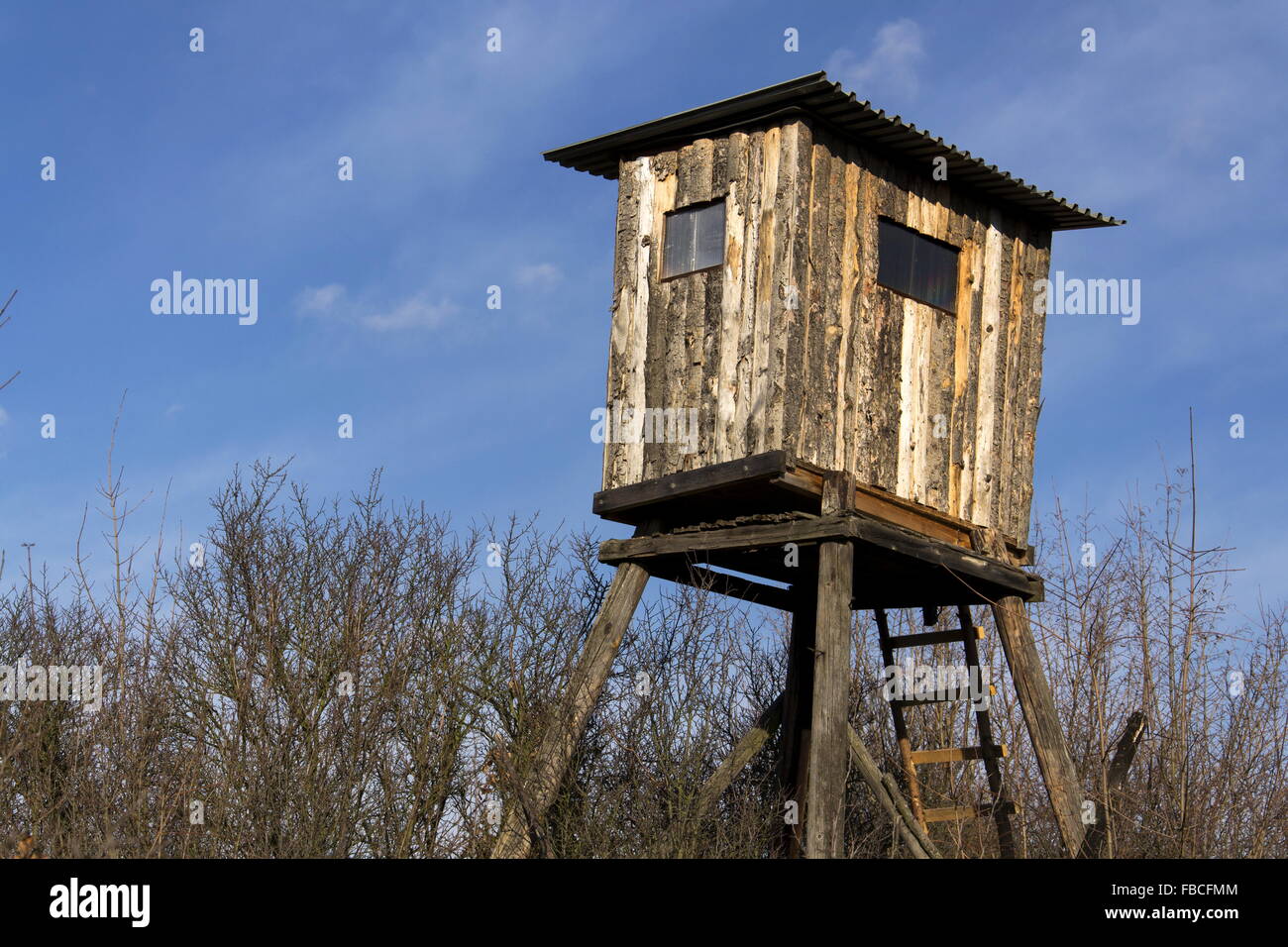 Wooden hunters high seat hide in forest with blue sky background Stock ...