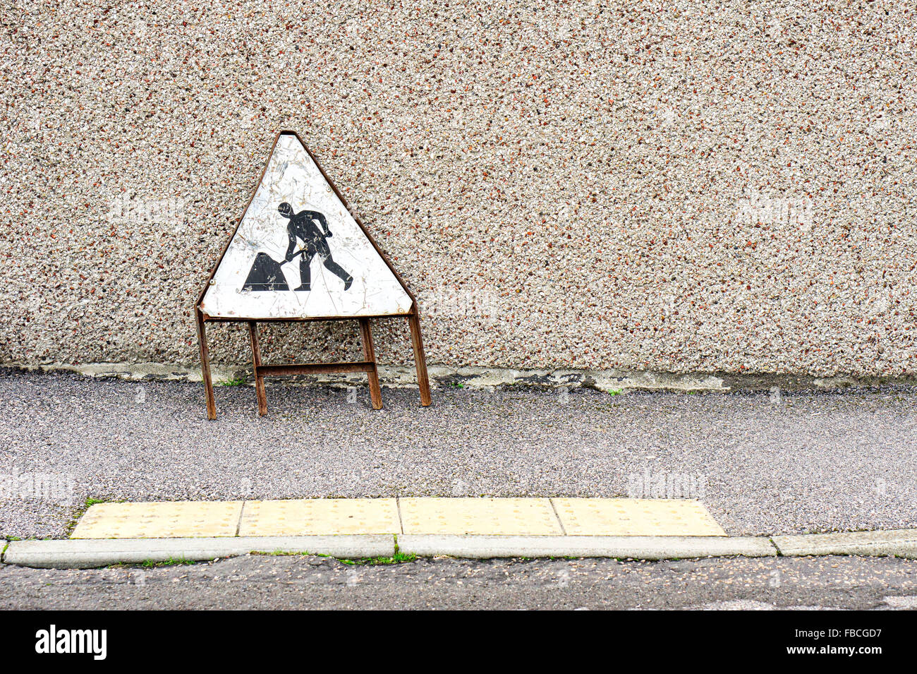 A rusty warning sign for roadworks, on a pavement in Scotland Stock ...