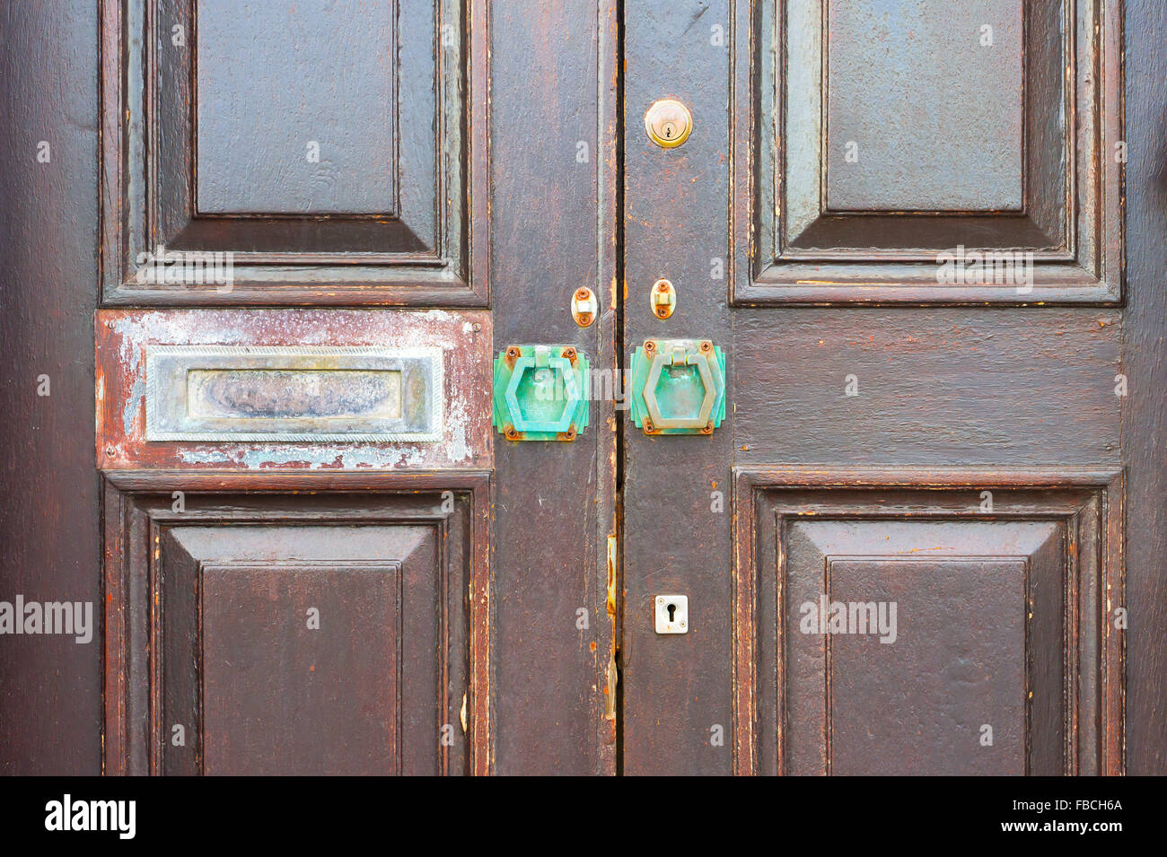 A weathered wooden door with a rusted letterbox Stock Photo - Alamy