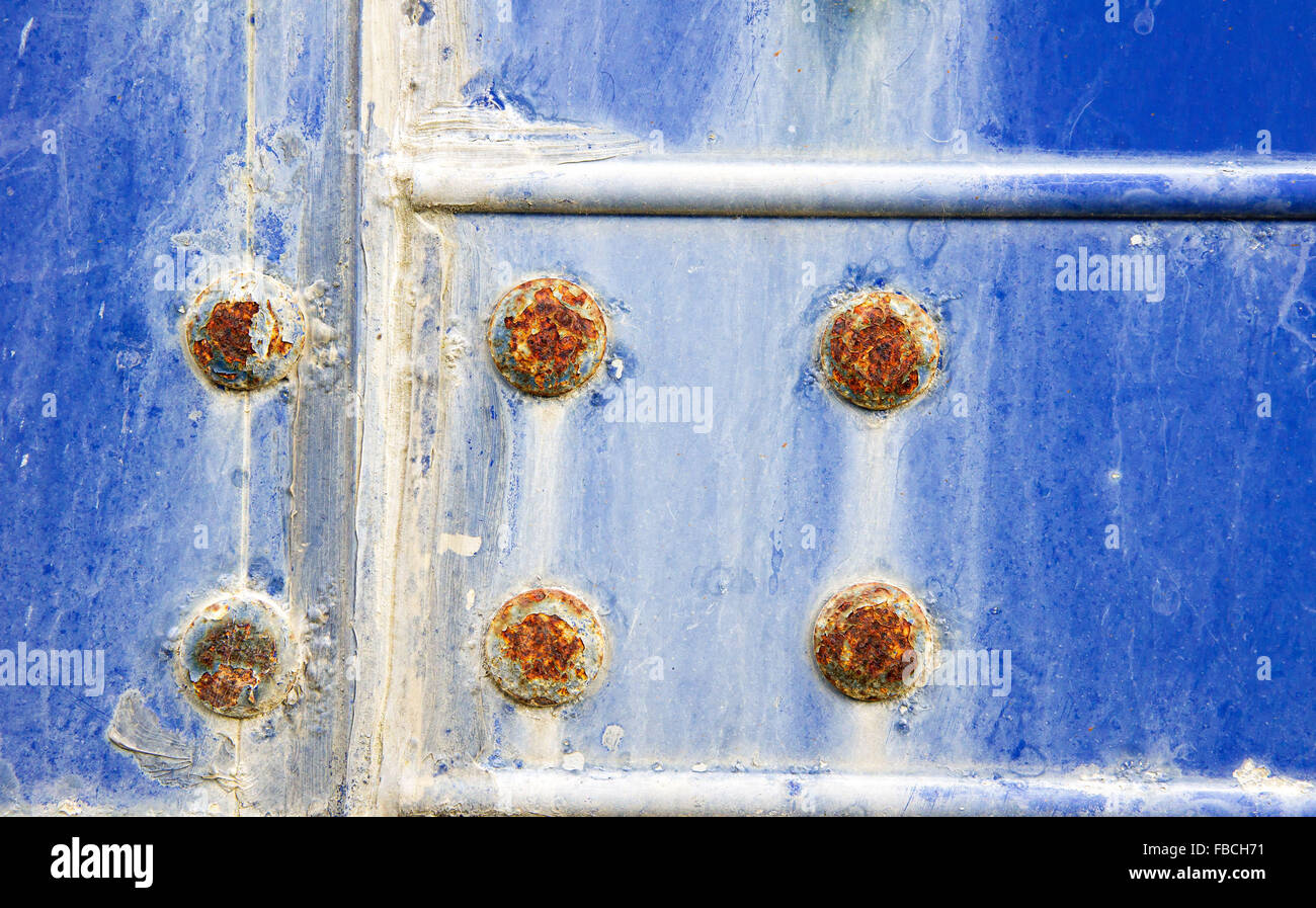 Part of a weathered blue metal surface with rusty bolts Stock Photo - Alamy