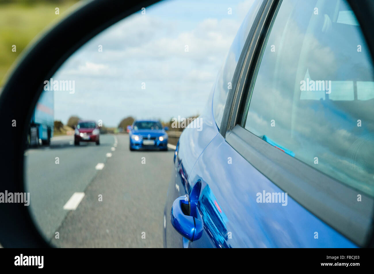 View from a cars wing mirror looking back at the traffic behind on a ...