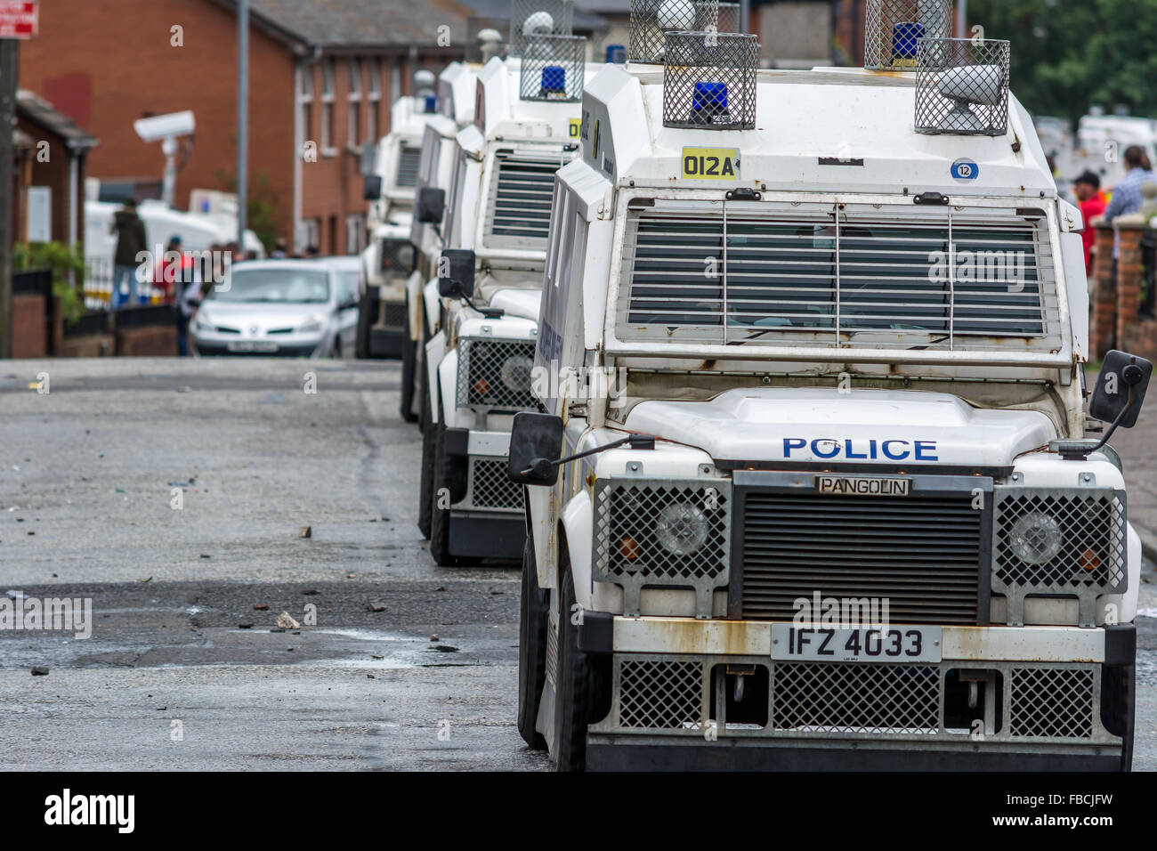 A line of PSNI land rovers drive through Belfast street after a riot in ...
