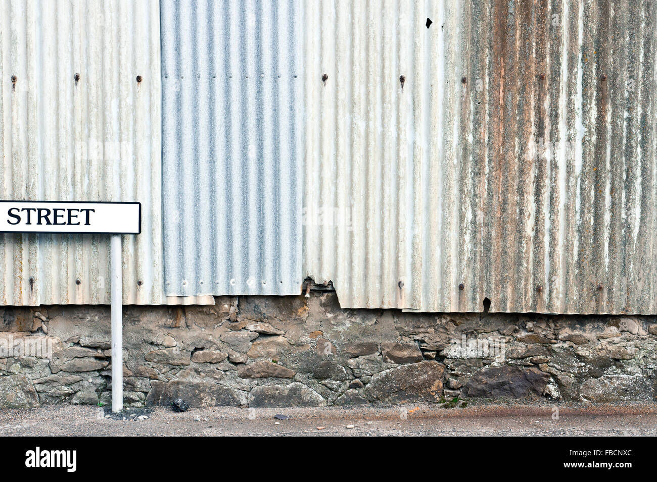 A modern white street sign in front of an old metal building Stock ...