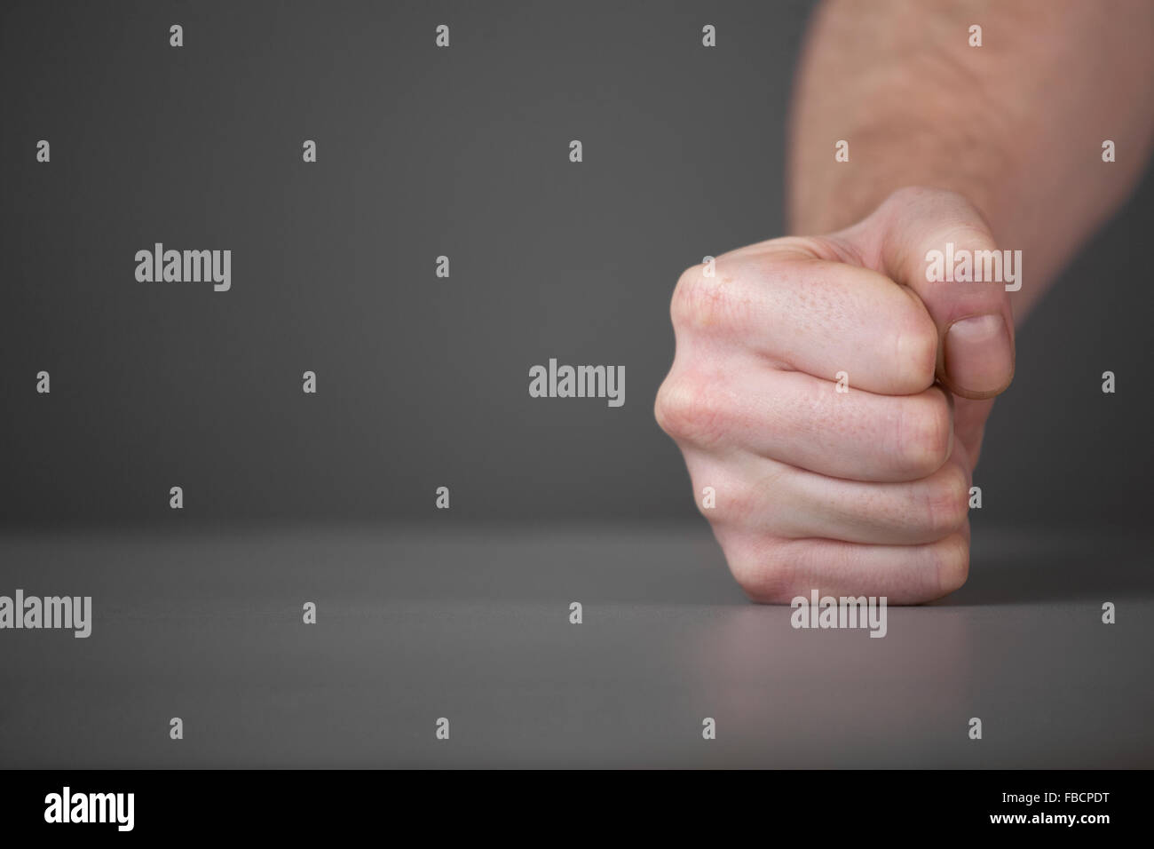 Male fist on the table Stock Photo - Alamy