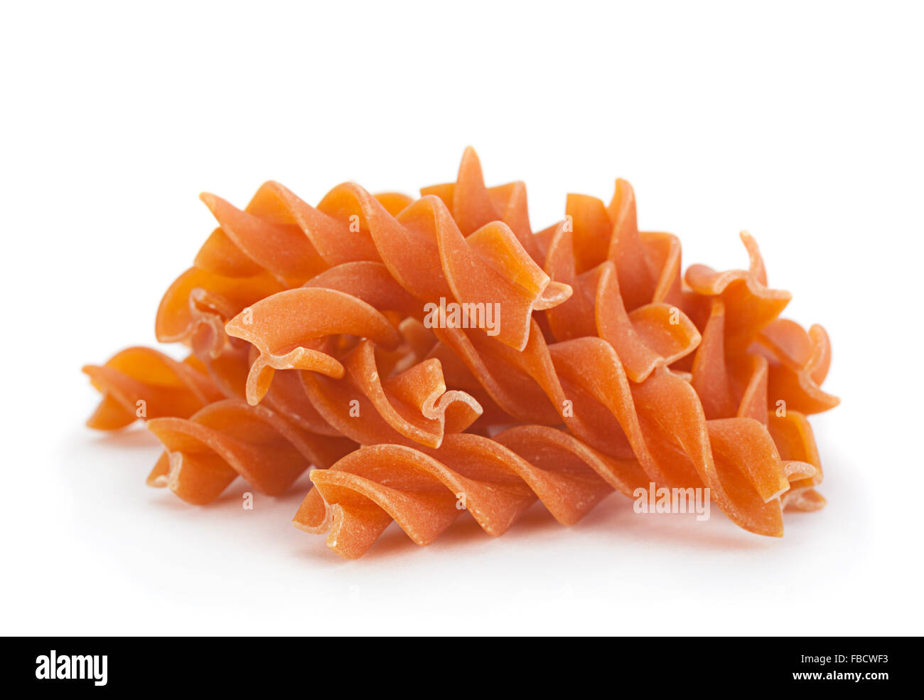 Orange swirl dry pasta closeup isolated on white background Stock Photo ...