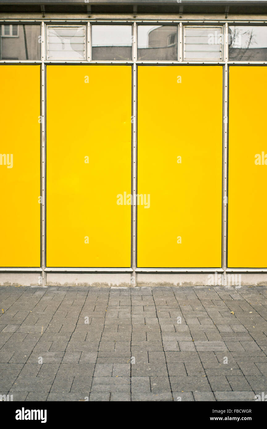 Part of the exterior of a temporary building with bright yellow panels ...