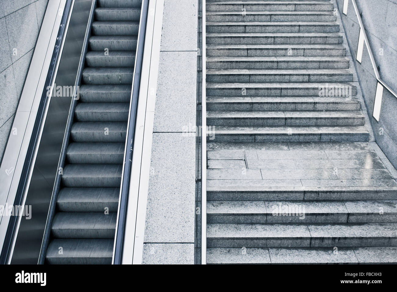 An escalator next to a flight of stone stairs Stock Photo - Alamy