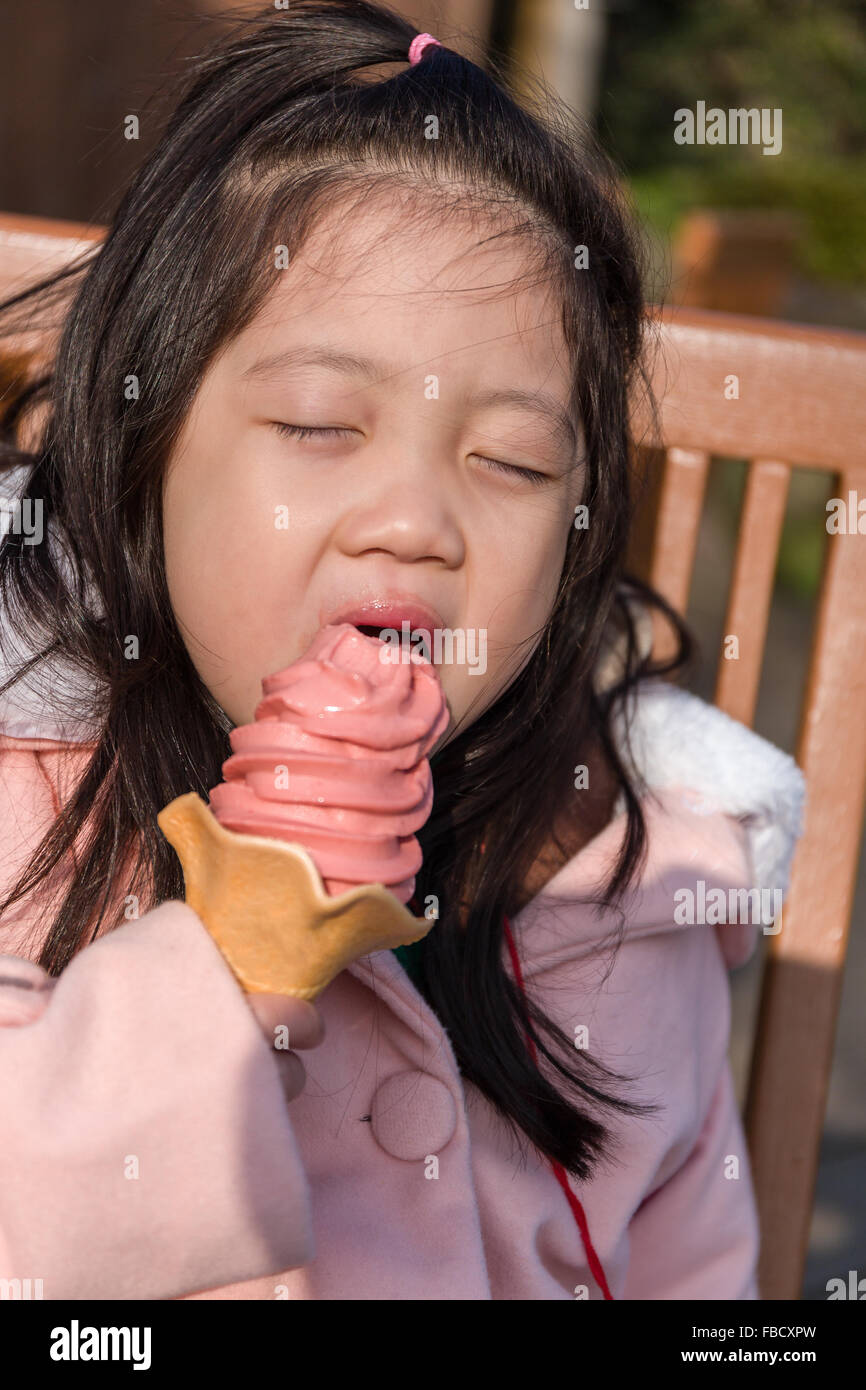 Young Asian girl eating her strawberry ice cream Stock Photo - Alamy
