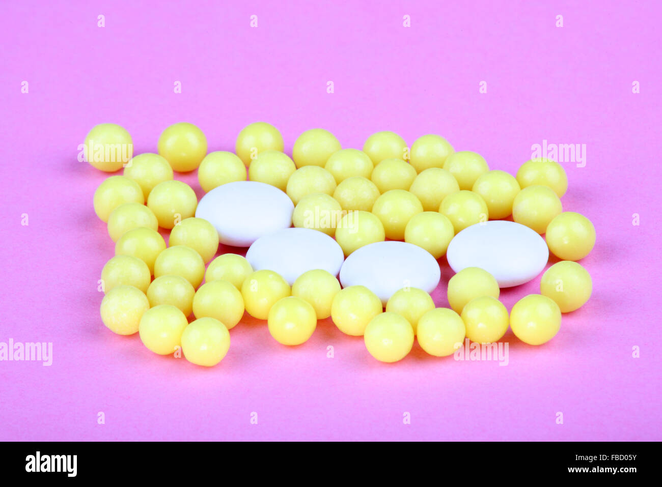 yellow vitamins on pink background Stock Photo - Alamy