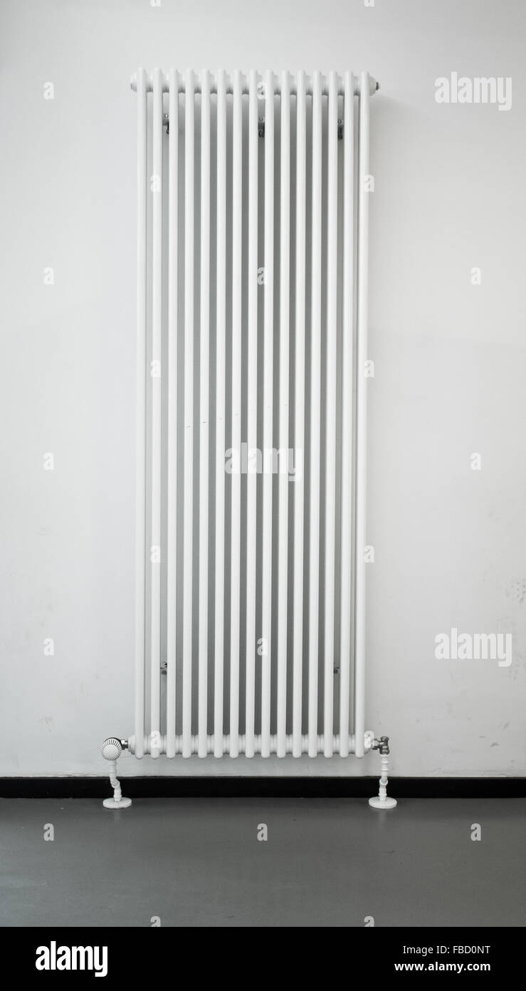 A tall white radiator against a white wall Stock Photo - Alamy