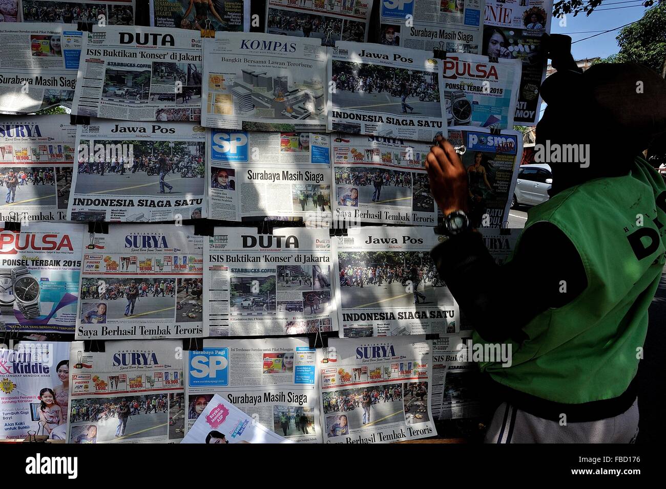 Surabaya, Indonesia. 15th Jan, 2016. A newspaper vendor sells newspaper ...