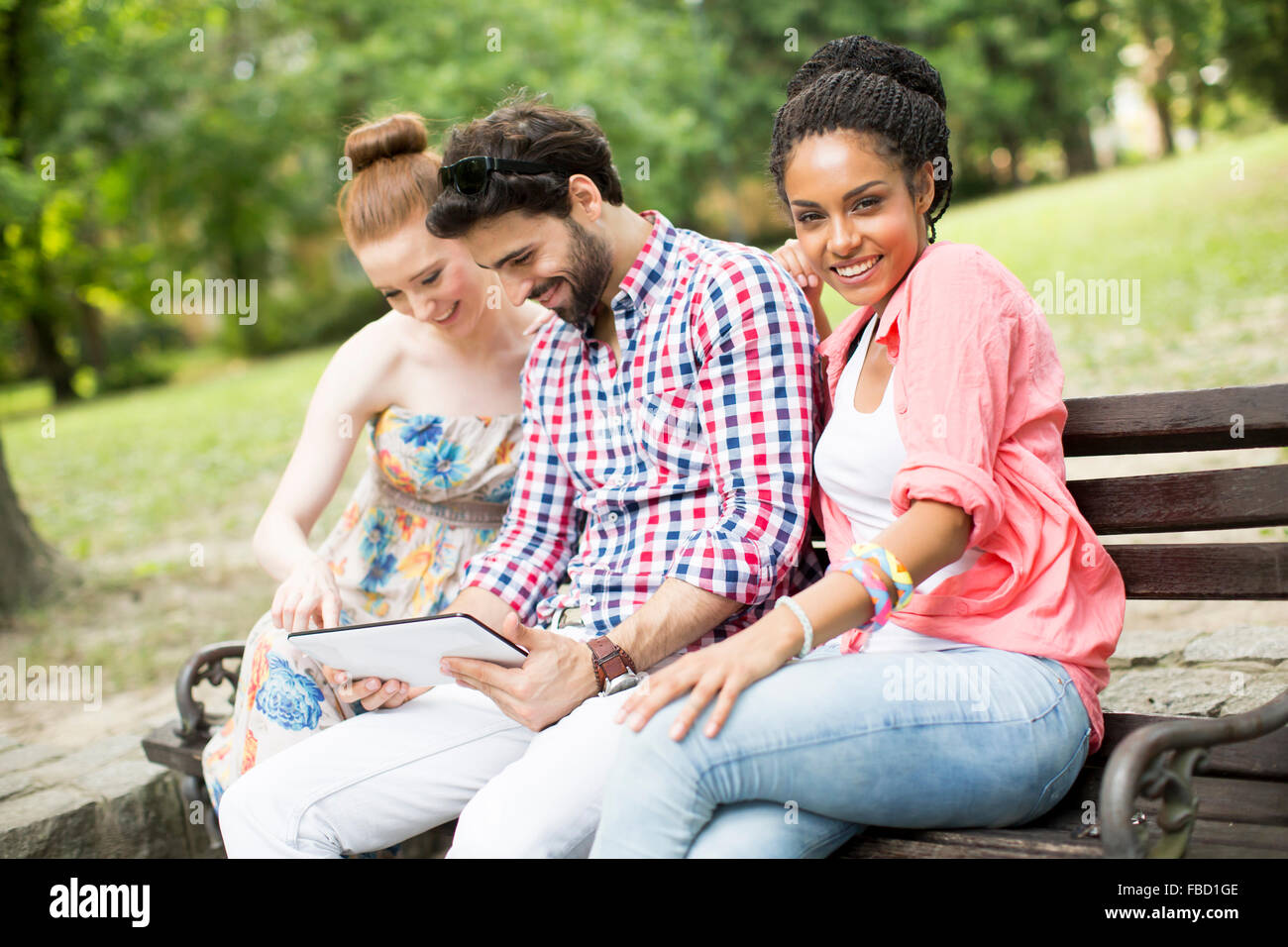 Three friends sitting park hi-res stock photography and images - Alamy
