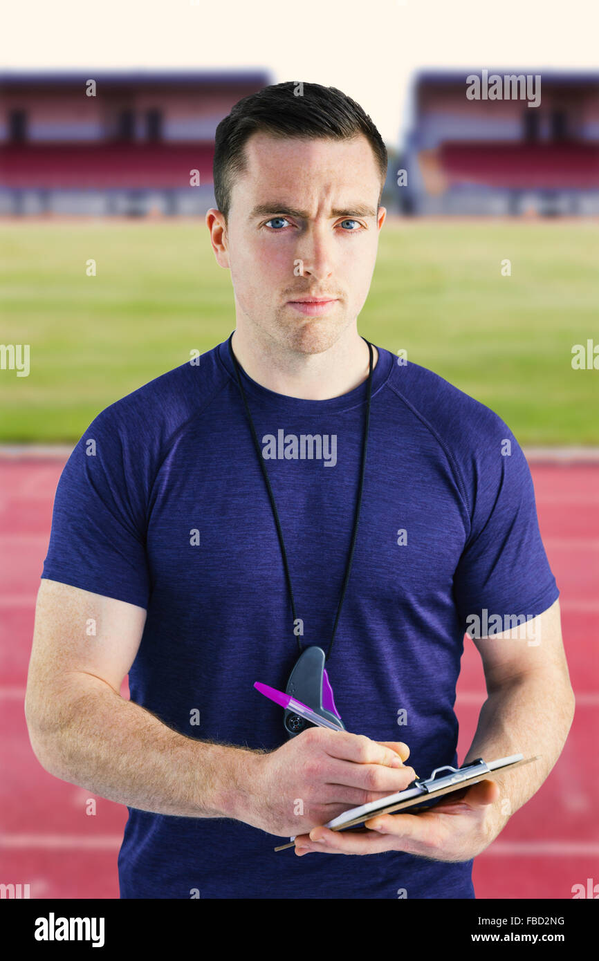 Composite image of smiling trainer holding a clipboard Stock Photo - Alamy