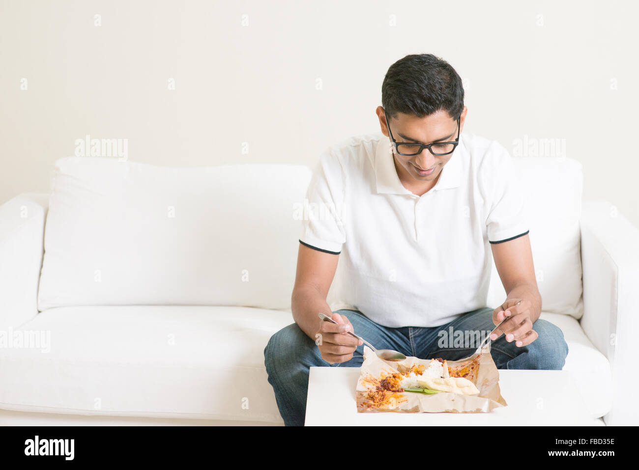 Lonely single Asian Indian man eating food alone at home, copy space at ...