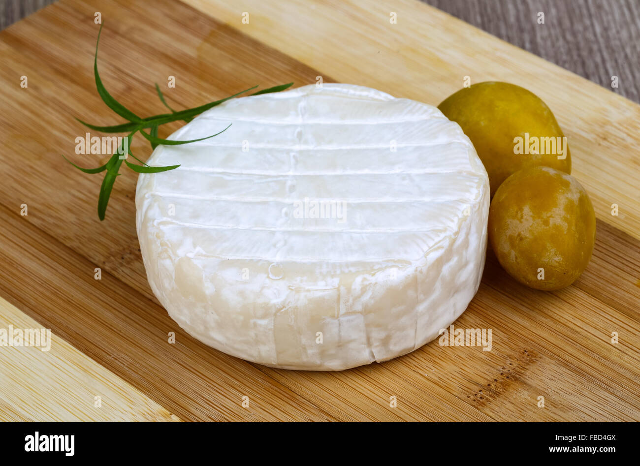 Round Brie cheese with yellow plums and estragon Stock Photo - Alamy