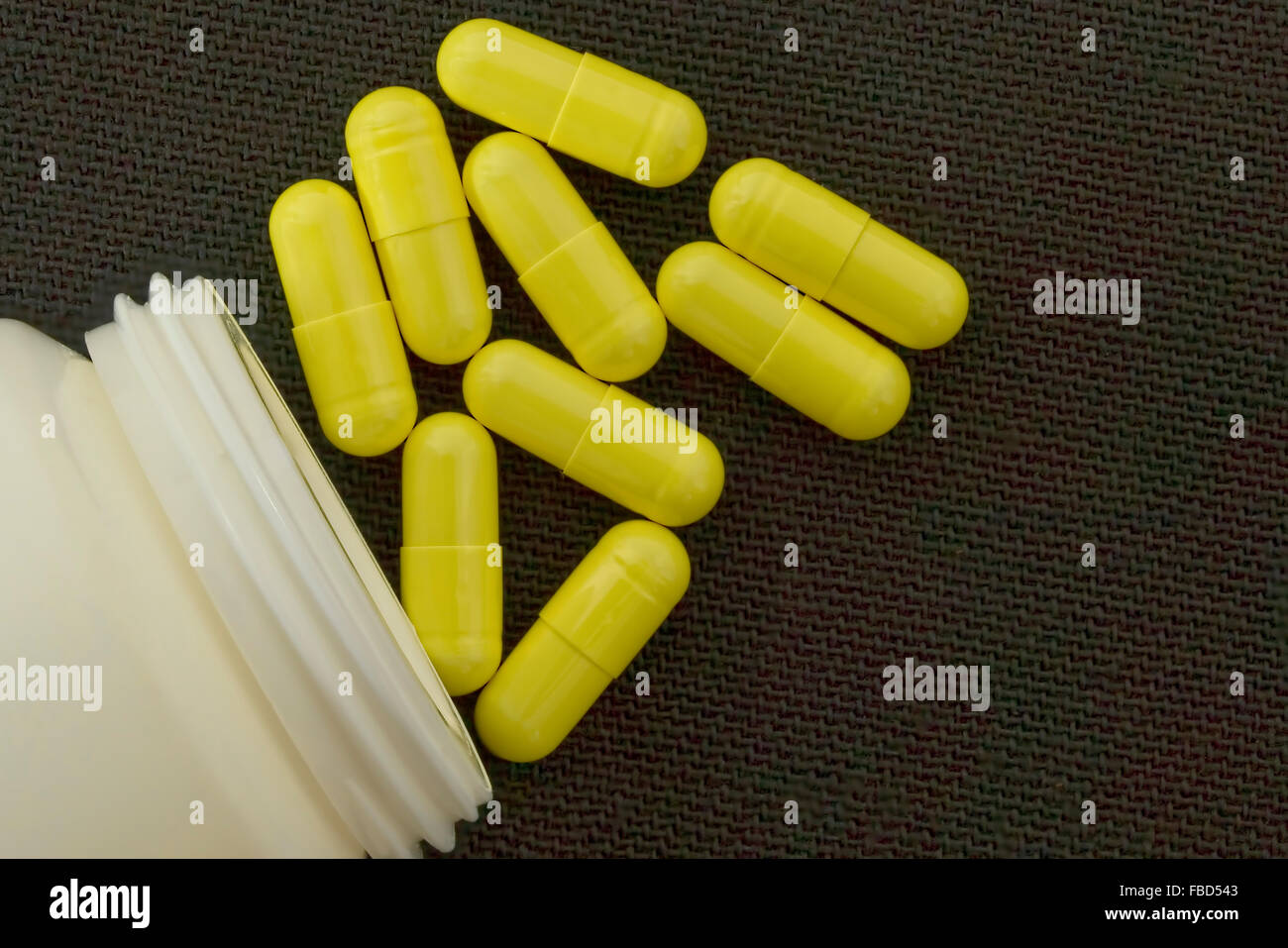 Yellow medicine Capsules on a black background Stock Photo - Alamy