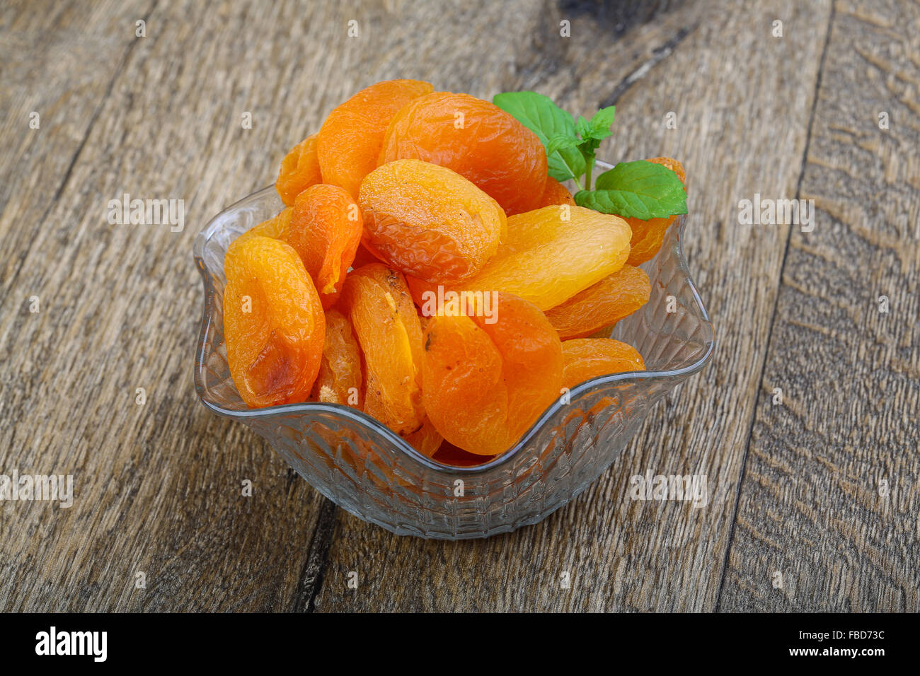 Dried apricots in the bowl on the wood background Stock Photo - Alamy