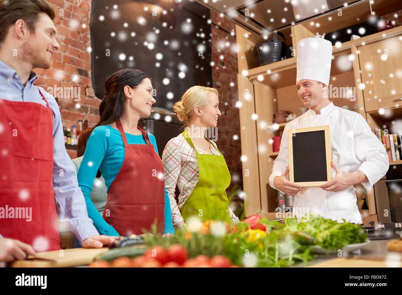 happy friends and chef cook with menu in kitchen Stock Photo - Alamy