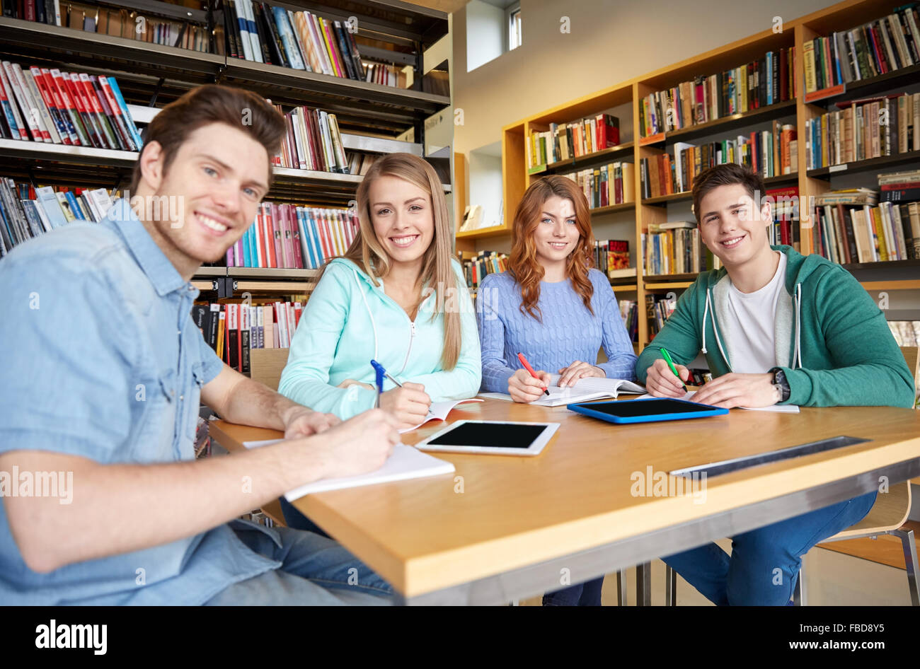 happy students writing to notebooks in library Stock Photo - Alamy