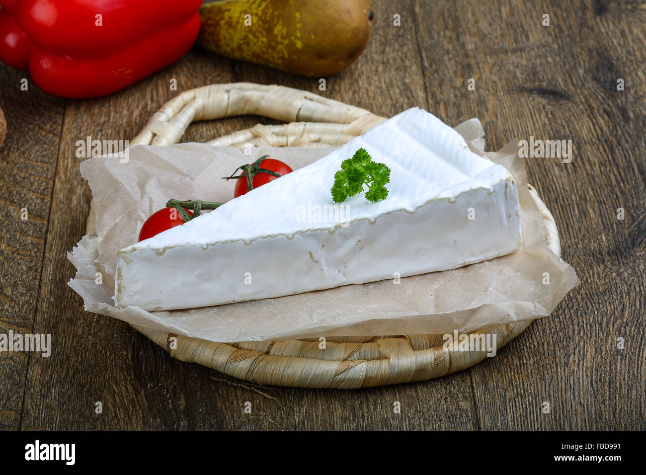 Brie cheese triangle with tomato and parsley Stock Photo - Alamy