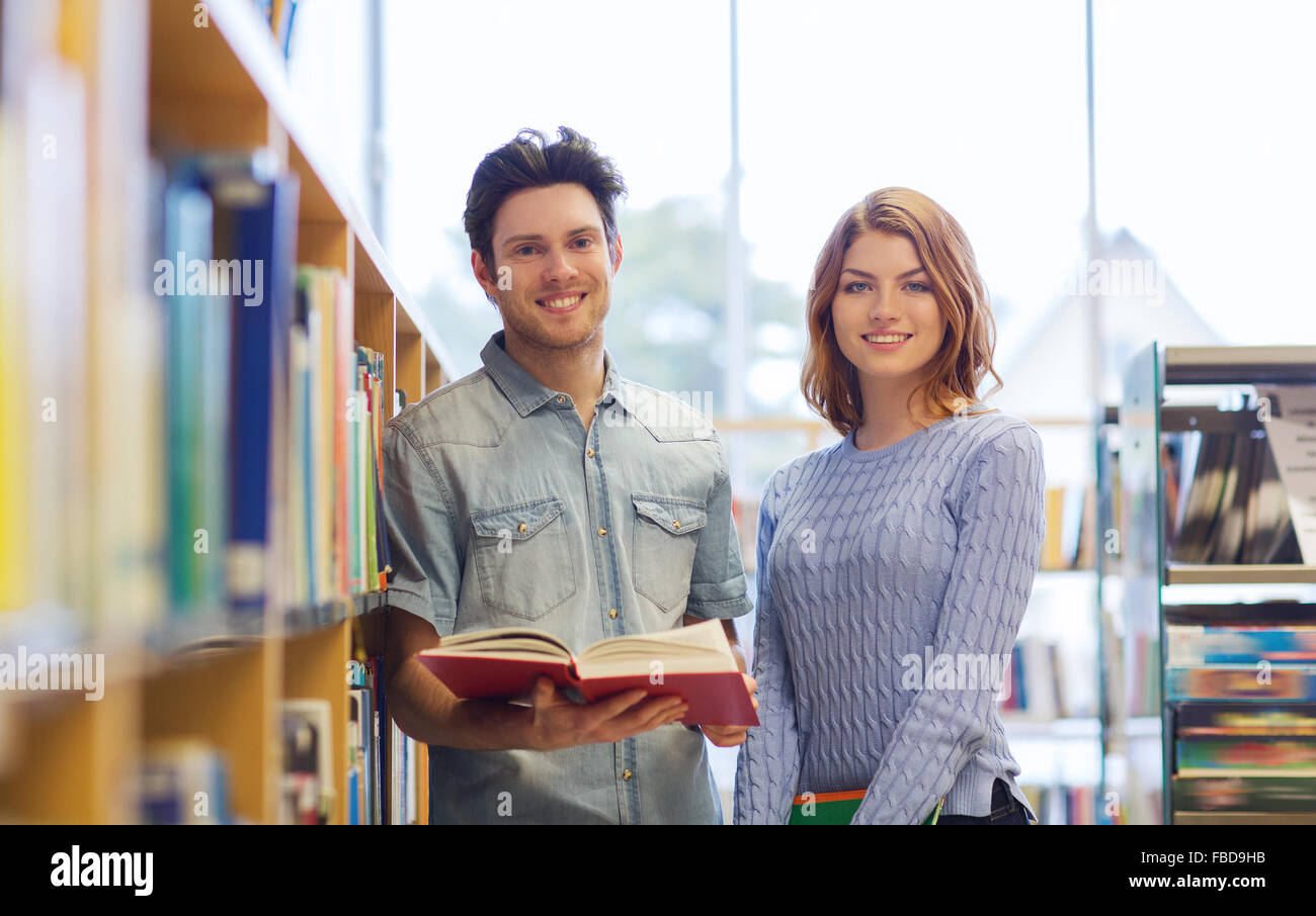 happy student couple with books in library Stock Photo - Alamy
