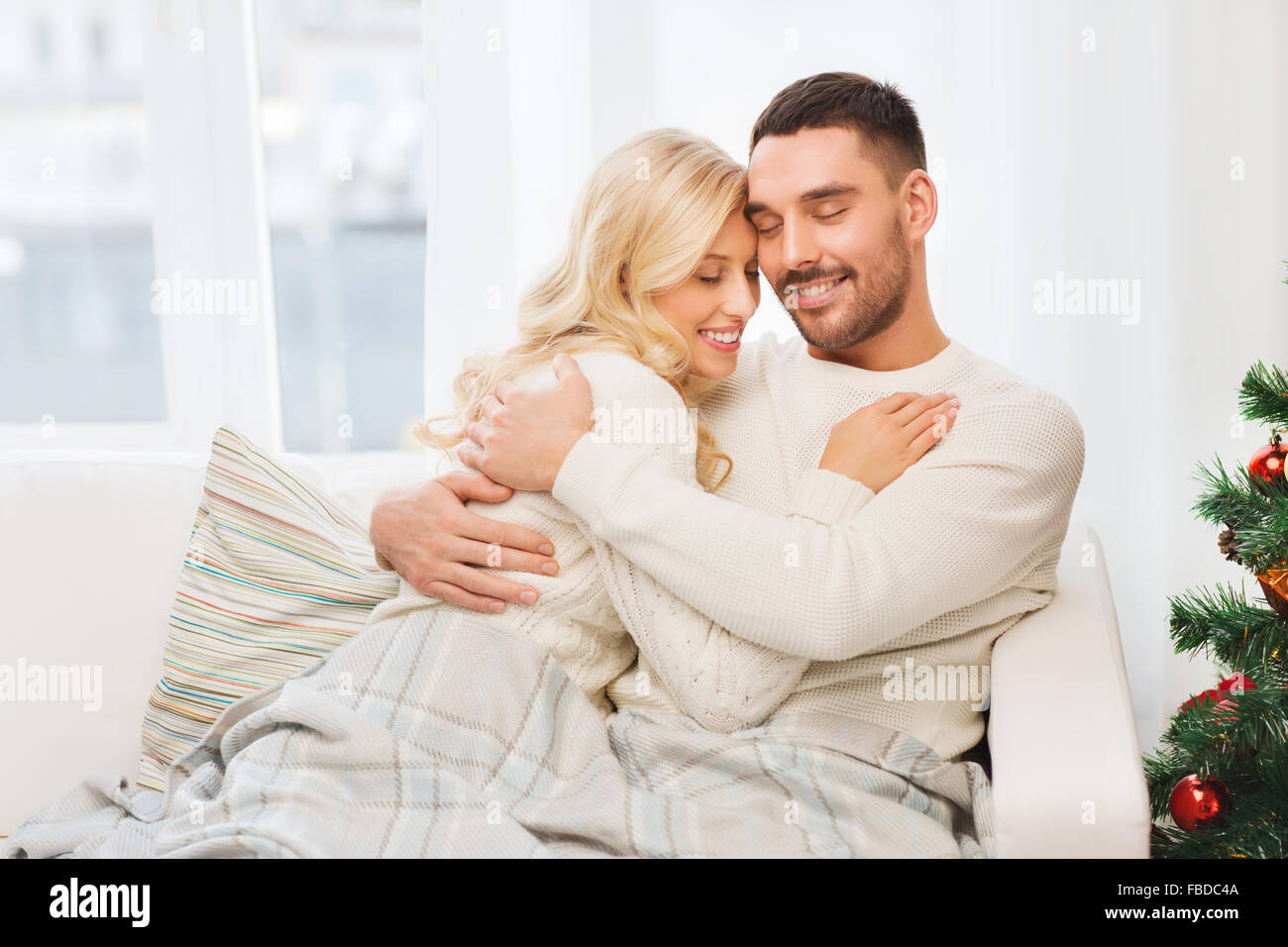 Romantic couple hugging on sofa hi-res stock photography and images - Alamy